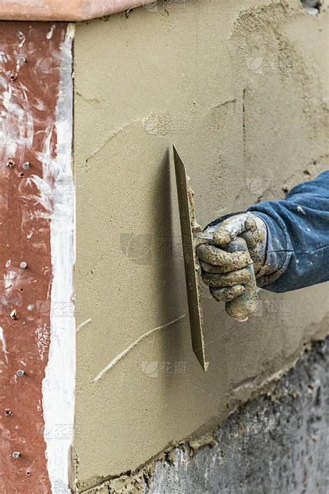 瓦工在水池施工现场用泥铲涂抹水泥