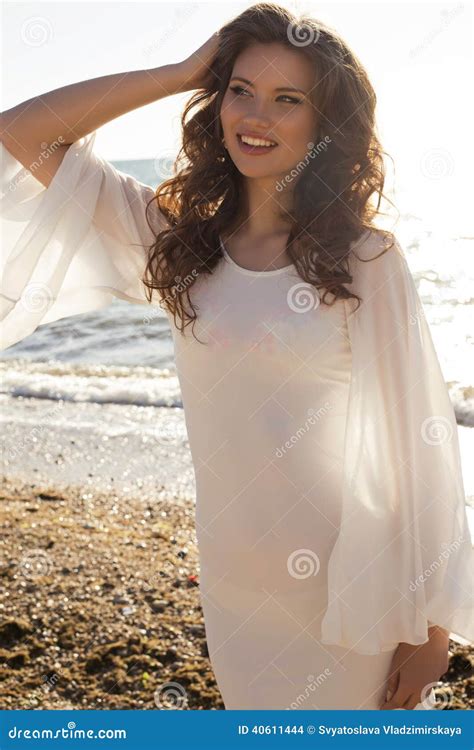 Красивая девушка при темные волосы представляя на пляже Стоковое Фото изображение