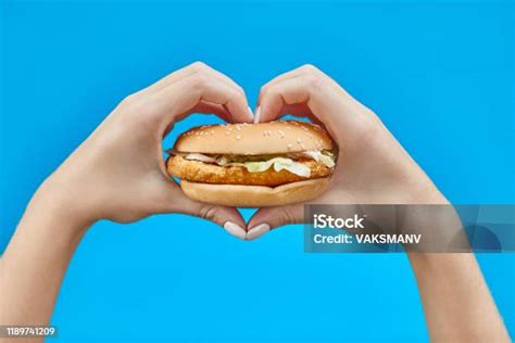 파란색 배경에 햄버거를 들고 여자 손 햄버거와 심장 기호를 만드는 두 손 건강한 식생활에 대한 스톡 사진 및 기타 이미지 건강한 식생활 고기 굽기 Istock