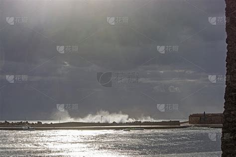 地中海海景与码头与黑暗的天空与戏剧性的光