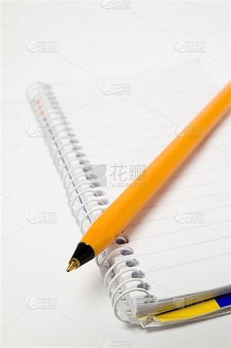 白色背景上的笔记本和黄色钢笔