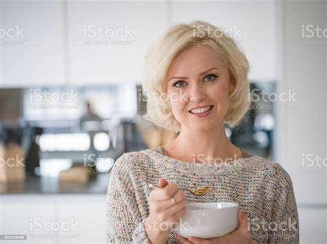 집에서 그 라 놀라의 그릇을 먹고 아름 다운 여자의 초상화를 카메라 웃 고 보고 20 29세에 대한 스톡 사진 및 기타 이미지 20 29세 30 39세 가정 생활