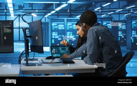 Multiethnic Coworkers Doing System Analysis Of Server Farm