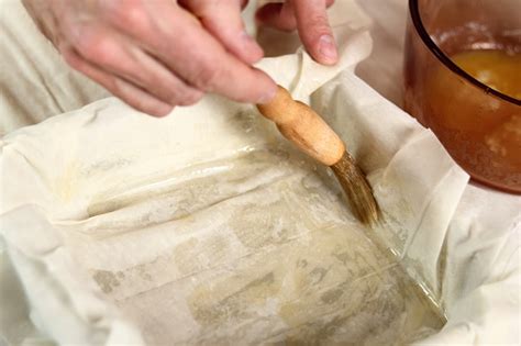 버터로 솔 질 필로 페스트 리 시트입니다 감자와 부추 필로 파이 만들기 시리즈입니다 날것에 대한 스톡 사진 및 기타 이미지