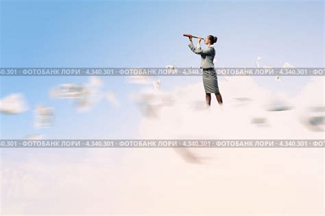 Стройная деловая женщина смотрит в подзорную трубу стоя на облаке Стоковое фото № 4340301