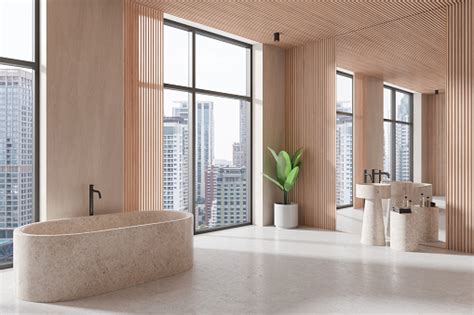 대형 욕조 현대적인 세면대 식물을 갖춘 고급스러운 욕실은 미니멀한 디자인으로 꾸며져 있습니다 천장부터 바닥까지 내려오는 대형 창문을 통해 탁 트인 도시 전망을 감상하실 수