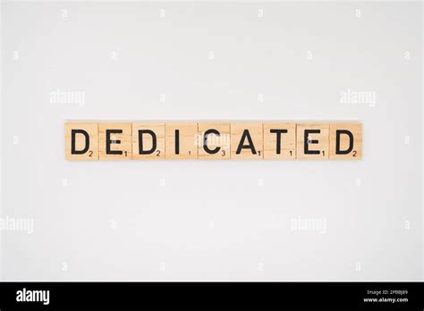 Wooden Title Spelling The Word Dedicated Isolated On A White Background