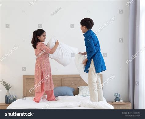 3 Sibling Brother Sister Wearing Traditional Clothes Having Fun Time Pillow Fighting Bedroom