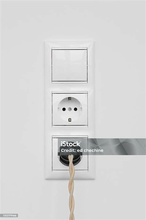 흰색 플라스틱 전기 콘센트 두 개의 블록과 흰색 석고 벽에 격리 된 스위치 빈티지 전기 케이블과 연결된 전기 유럽 콘센트 복사 공간이 있는 클로즈업 0명에 대한 스톡 사진