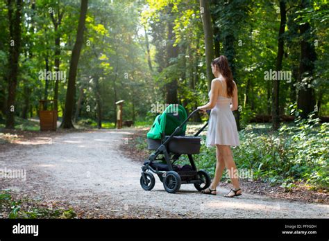 Woman In Dress Walking With The Pram Surrounded By Beautiful Nature