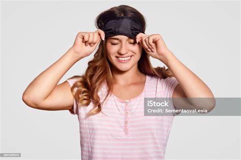 다행 낙관적 백인 여자 아이 마스크를 착용 즐거운 꿈을 보고 흰색 배경 모델 광범위 한 미소 잠 옷을 입고 있다 행복 한 식이