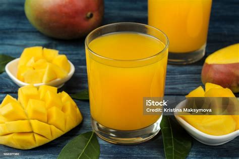 잘 익은 신선한 망고 과일과 조각 망고 주스가 파란 나무 테이블에 유리잔에 담겨 있다 열대 과일 0명에 대한 스톡 사진 및 기타 이미지 Istock