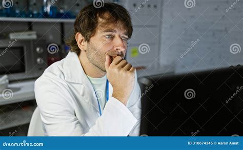 Pensive Man With Beard In Lab Coat Analyzing Data On Computer In