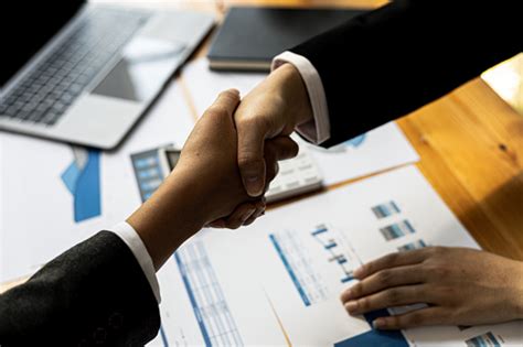 두 명의 사업가가 손을 잡고 있는 클로즈업 두 명의 사업가가 함께 사업에 동의하고 성공적인 협상 후 악수를 하고 있습니다 핸드쉐이는 서양 인사말이나 축하입니다 2명에 대한