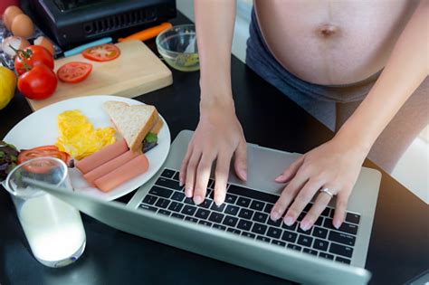 임신 개념입니다 아름 다운 엄마 또는 임신 한 여자 부엌에서 랩톱 컴퓨터를 사용 하 여 웹 사이트에서 음식의 영양 사실의 검색 정보 감독에서 남편이 나 가족과 채팅 임신 한