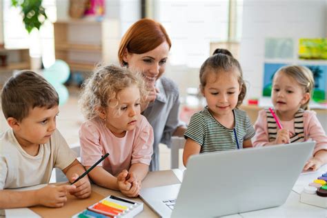 교실 실내 바닥에 교사가 있는 작은 보육원 아이들 그룹이 노트북을 사용합니다 사진 Unsplash의 컴퓨터 이미지
