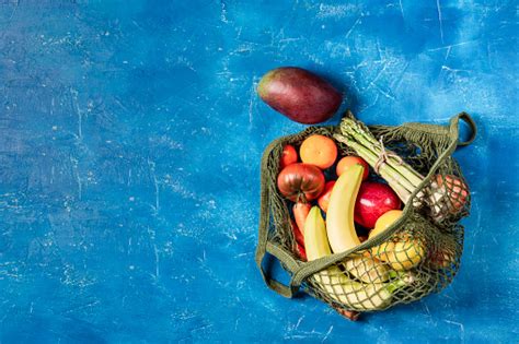 밝은 파란색 배경에 녹색 문자열 가방에 신선한 야채와 과일 플라스틱 천연 소재 및 천연 제품만 없습니다 가방에 대한 스톡 사진 및 기타 이미지 Istock