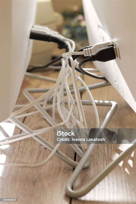 두 개의 모니터 또는 컴퓨터에 연결된 케이블과 전선의 얽힘 샷은 낮은 각도에서 촬영됩니다 사진은 혼돈 무질서 작업 공간 구성의 문제를 전달합니다 Usb 케이블에 대한 스톡