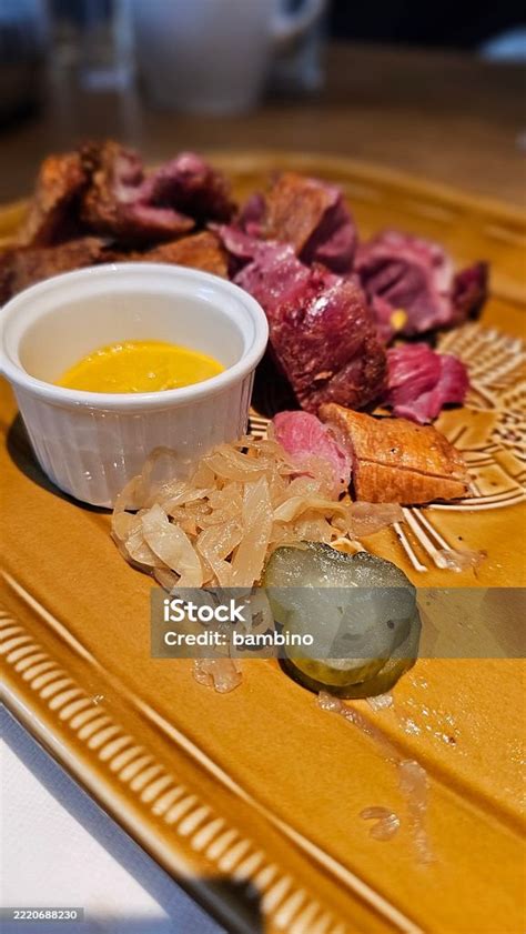 바삭한 전통 독일 요리 소금에 절인 양배추를 곁들인 얇게 썬 구운 돼지 손가락 관절 절인 오이 소박한 도자기 접시에 담긴 노란