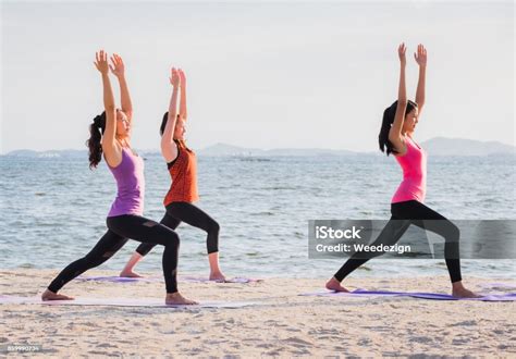 저녁 조개와 함께 전사 포즈를 하는 사람들의 그룹에에서 바다 해변에서 요가 클래스 해변 명상 포즈 웰빙과 건강 한 균형 라이프 스타일에서 감정 긴장 균형에 대한 스톡 사진