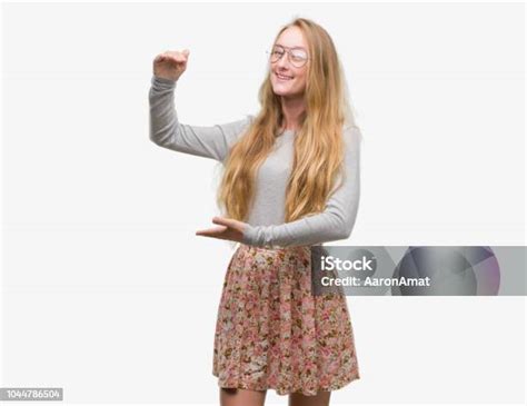 금발 십 대 여 자가 보여주는 큰 손 및 큰 크기 표시 측정 기호 몸짓 꽃 치마를 입고 카메라를 보고 웃 고 측정 개념입니다 개념에 대한 스톡 사진 및 기타 이미지 Istock