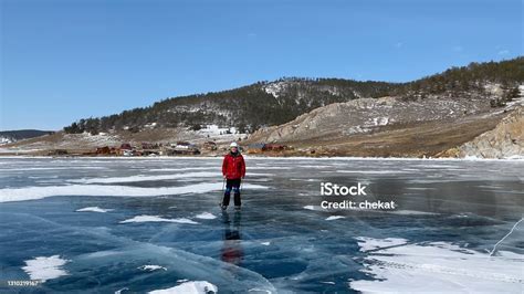흰색 헬멧 아이스 스케이트 무릎 패드 스키 폴을 입은 남자가 얼어붙은 바이칼 호수의 얼음 위에서 굴러가고 있습니다 3월에 대한 스톡 사진 및 기타 이미지 Istock