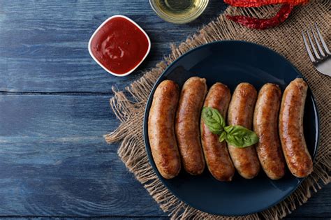 파란색 나무 배경에 빨간 소스와 향신료가 들어간 접시에 맛있는 구운 소시지 비비큐 상위 뷰 Celebrity Roast에 대한 스톡 사진 및 기타 이미지 Istock