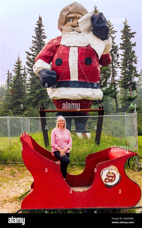 Senior Woman Posing With Huge Outdoor Statue Of Santa Claus North Pole