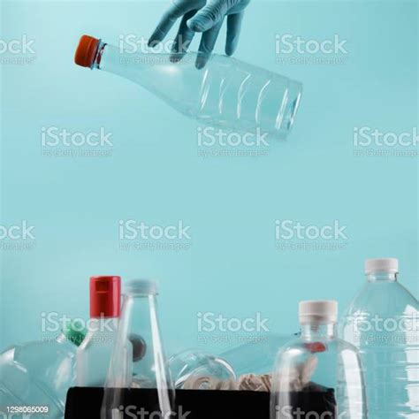 중고 플라스틱 병을 쓰레기통에 떨어뜨리는 청소 장갑을 손으로 넣습니다 재사용 재활용 및 폐기물 제로 캠페인 개념 환경 관리 0에