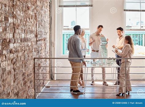 Group Of Diverse Architects Discussing Plans Blueprints And Schematics During A Meeting In