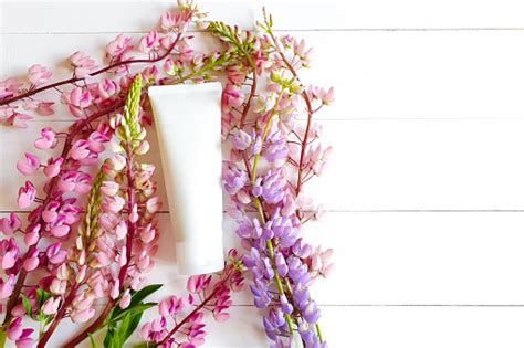 브랜드가 없는 흰색 스퀴즈 병 플라스틱 튜브와 분홍색 루핀 꽃 배경 브랜딩 및 라벨용 병 천연 유기농 스파 화장품 복사 공간 꽃 평탄 모형 상단 보기 0명에 대한 스톡 사진