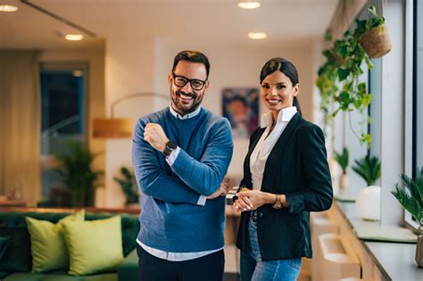 사무실에 서 있는 두 명의 성인 동료가 우아하게 옷을 입고 카메라를 향해 포즈를 취하고 있다 25 29세에 대한 스톡 사진 및 기타 이미지 Istock