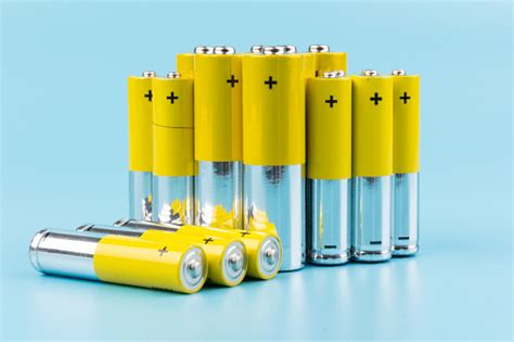 파란색 배경에 회색 노란색 알칼리성 Aa 배터리의 사진 충전식 Nimh 배터리의 재활용 가장 인기있는 어큐뮬레이터 크기입니다 공간을 복사합니다 더미에 대한 스톡 사진 및