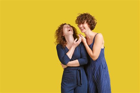 잘생긴 젊은 곱슬 유럽 여성 블루 전반적으로 뭔가 세련 된 빨간 머리 소녀 공유 하는 최신가 십의 귀에 속 삭 여 충격에서 보고