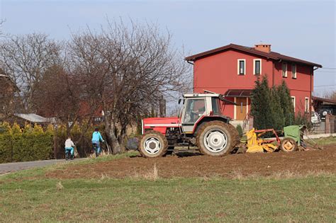 시더와 빨간 트랙터에 농부 곡물 경작 마 지역에서 개인 필드에서에 뿌리 스프링 필드 작업 기계화 농부의 일상 생활입니다 토지의 처리 농촌입니다 2명에 대한 스톡 사진 및