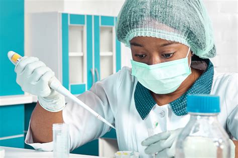 흰색 코트 보호 모자 및 장갑을 착용한 아프리카 과학자 기술 보조 자 또는 의료 기술자는 의료 테스트 실험실에서 새로운 코로나바이러스에 대한 Pcr 테스트를 최적화합니다