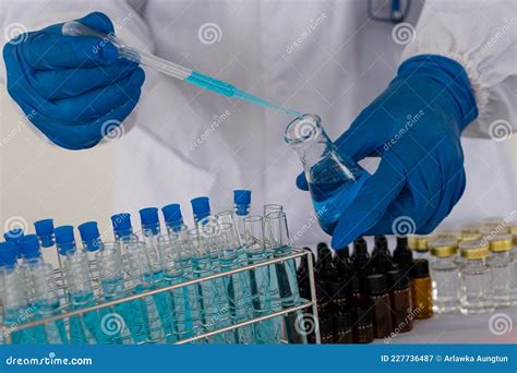 Asian Scientists Conducting Laboratory Experiments The Pipette Lowers The Sample Into A Close