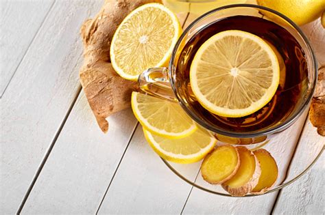 생강 레몬 민트 꿀이 들어간 녹차 한 잔이 나무로 된 소박한 배경에 있다 건강 음료 건강한 개념입니다 질병 예방 가을 겨울 차