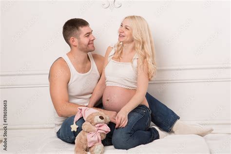 Beautiful Pregnant Couple In Love On The Background Hands Of Husband On The Tummy Of His