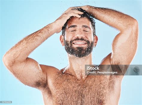 청소 모발 및 케라틴 치료는 위생을 위해 파란색 배경에 스튜디오에서 샴푸를 사용하는 남자 모델입니다 물 수분 및 자연 헤어 케어를 위해 샤워에서 잘 생긴 남성 세척 건강한