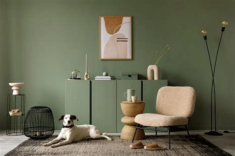 모형 포스터 프레임 현대적인 프로떼 안락 의자 나무 Commode 카펫에 누워 아름다운 개와 세련된 액세서리와 우아한 거실