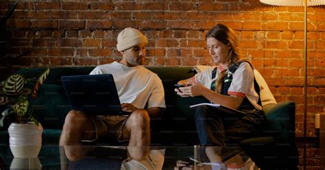 한 남자와 한 여자가 노트북을 들고 소파에 앉아 있다 사진 Unsplash의 코칭 이미지