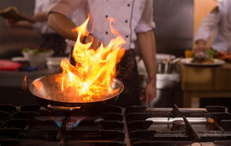 Premium Photo Chef Cooking And Doing Flambe On Food In Restaurant Kitchen
