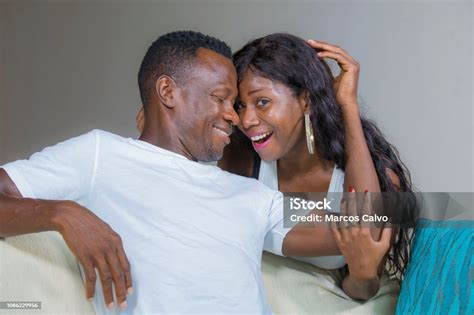 젊은 행복 하 고 성공적인 로맨틱 아프리카 미국 몇 사랑 편안 하 게 앉아 함께 거실 소파에서 편안 하 게 소파 껴 안고 고