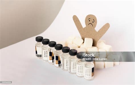 설탕 중독 인슐린 저항 건강에 해로운 다이어트 정제 된 설탕 큐브와 흰색 배경에 인슐린의 병에 둘러싸인 골판지 남자의 그림 당뇨병 보호 의료 개념 0명에 대한 스톡 사진 및