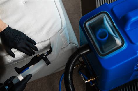 청소기는 집안의 침대 매트리스를 청소하기 위해 추출기를 사용하고 있습니다 추출기로 소파 섬유의 먼지를 흡수합니다 추출기를 사용한 매트리스 건조 세탁 가구에 대한 스톡 사진