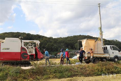 너른 들판 한 대의 콤바인 작은 농민들의 추수