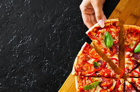 여자 손 걸립니다 슬라이스 모 짜 렐 라와 피자의 치즈 햄 토마토 살라미 페 퍼 페퍼로니 향신료와 신선한 바 질 검은 배경에 이탈리아 피자 고추류에 대한 스톡 사진 및 기타