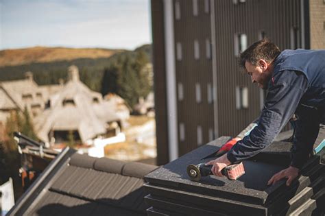 건설 노동자는 경량 금속을 절단 전기 각도 분쇄기로 코팅 지붕 시트를 페인트 지붕 이는 사람에 대한 스톡 사진 및 기타 이미지