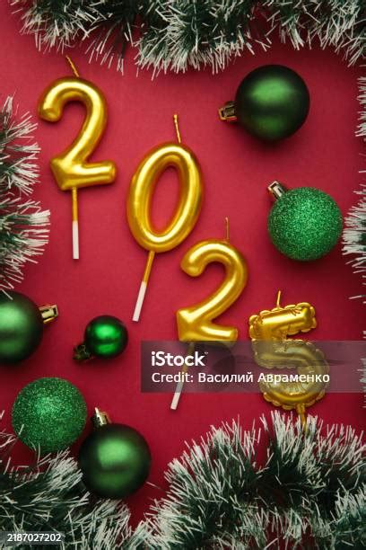 즐거운 성탄절 보내시고 2025년 새해 복 많이 받으세요 황금 양초는 빨간색 배경에 녹색 공을 가진 2025 번을 열거합니다 상의 View 0명에 대한 스톡 사진 및 기타